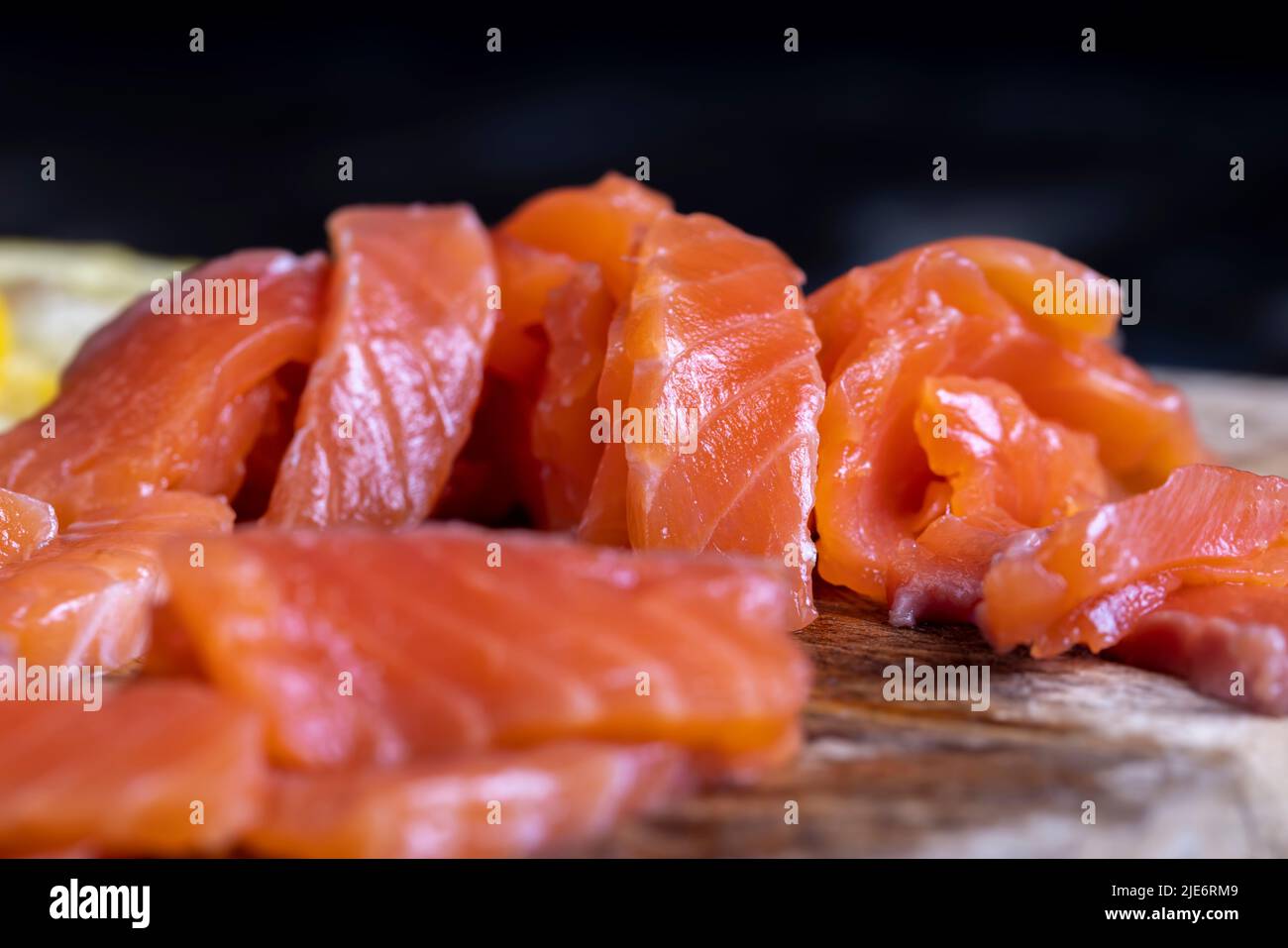 sliced red salted salmon during cooking, cutting fish fillets during ...