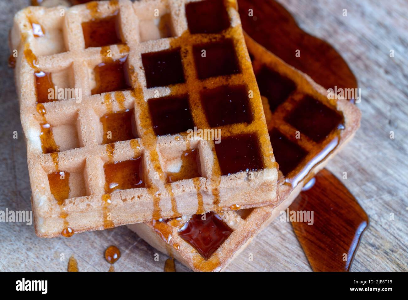 square sweet soft waffles in bee honey , a traditional European dessert ...