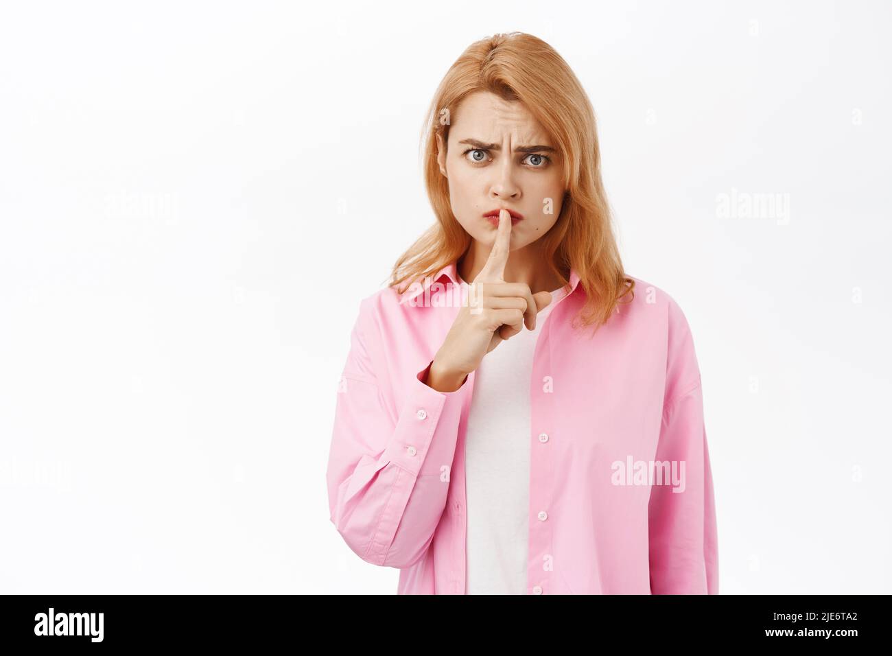 Upset woman shushing, making hush sign, silence gesture, tells to be ...