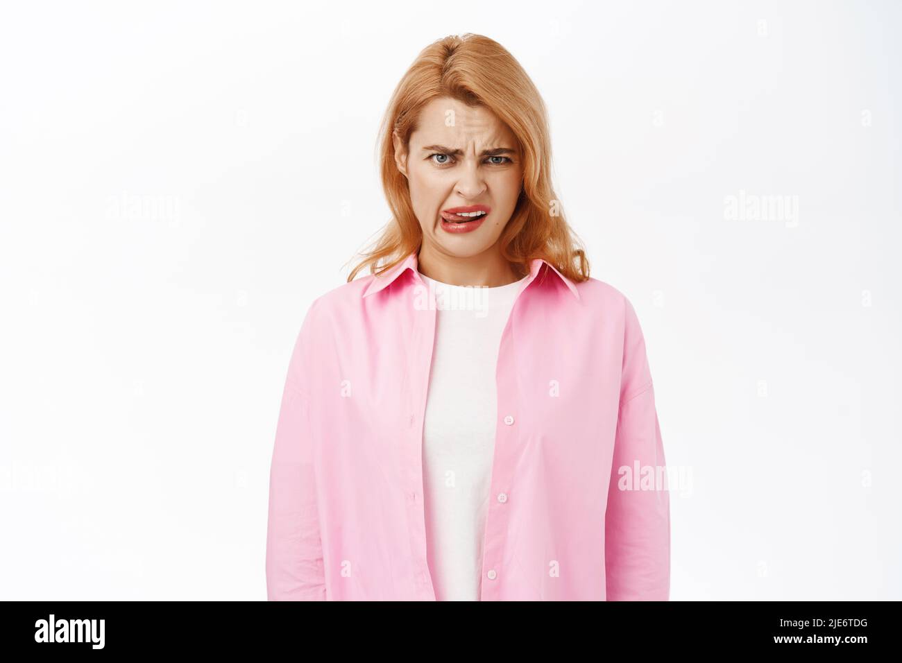 Portrait of woman showing tongue and look disgusted, bad taste of ...