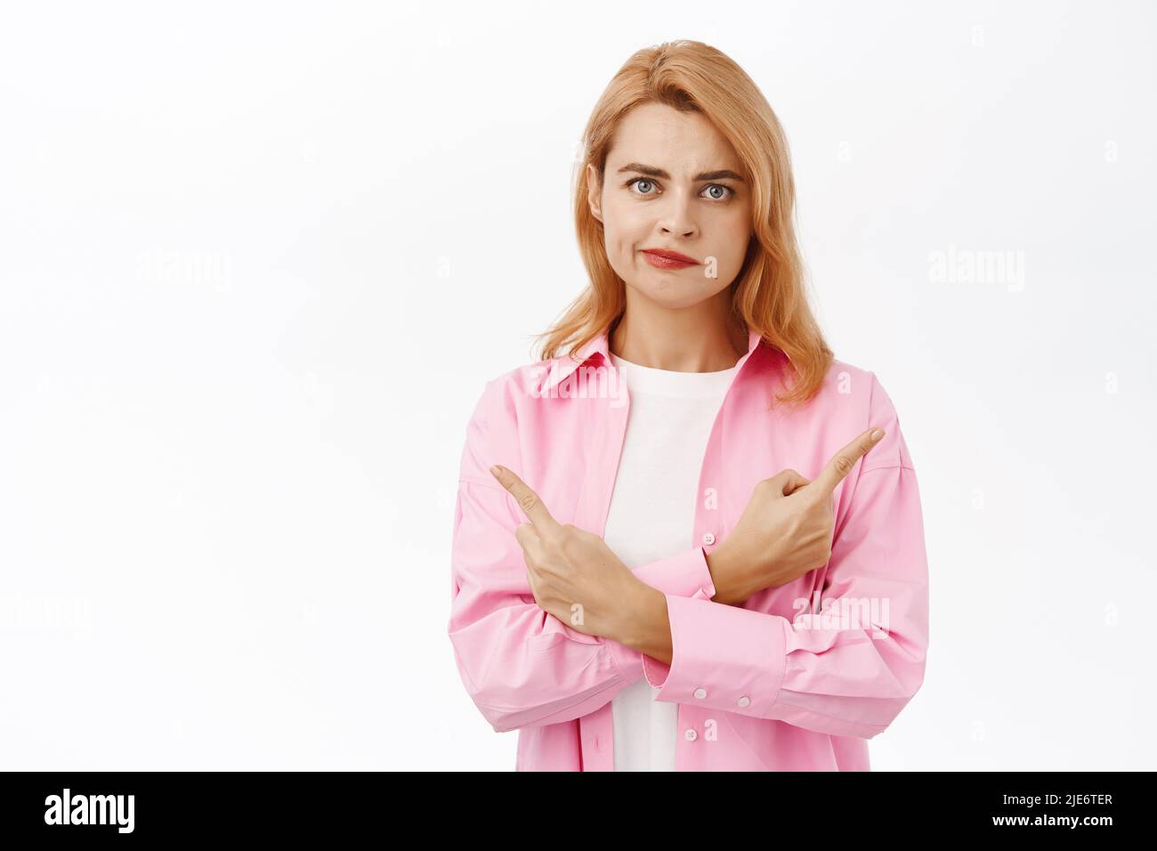 Perplexed young woman pointing sideways, showing left and right banner ...