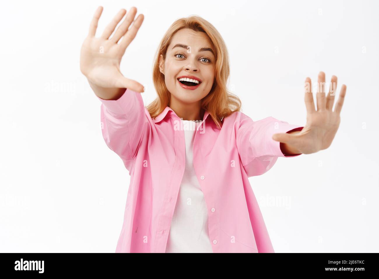 Happy and carefree young woman, looking through extended hands ...