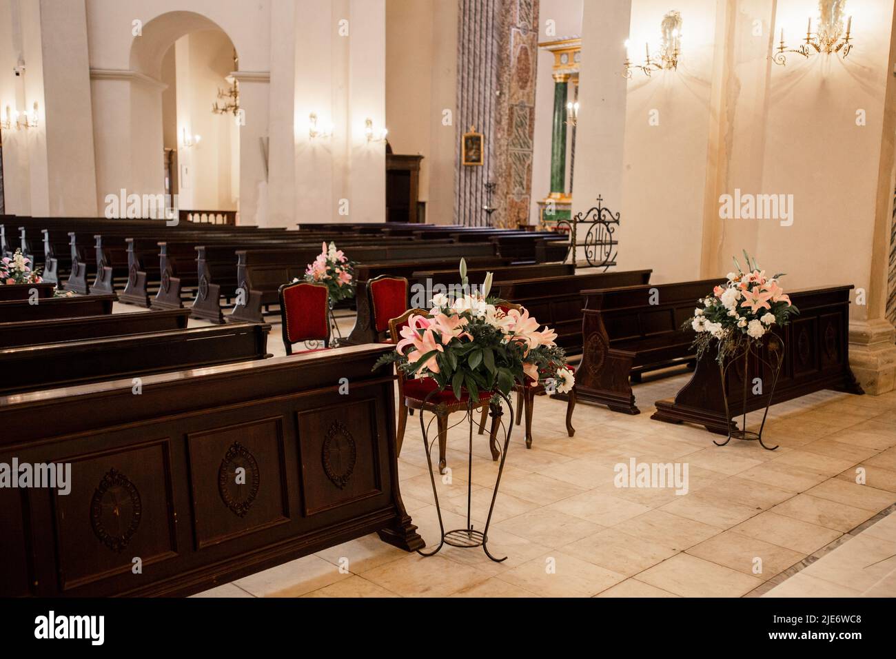 a decor of flowers in the Catholic Church and wooden benches Stock ...