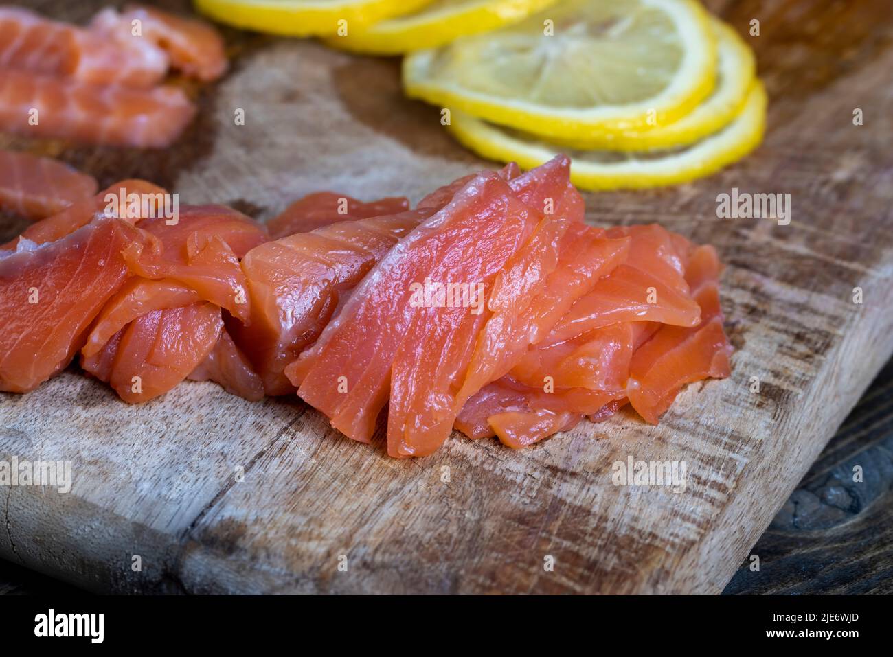 sliced red salted salmon during cooking, cutting fish fillets during ...