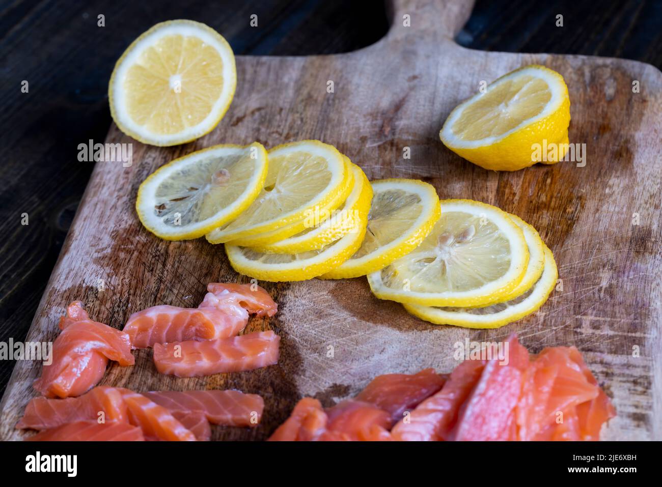 sliced red salted salmon during cooking, cutting fish fillets during ...