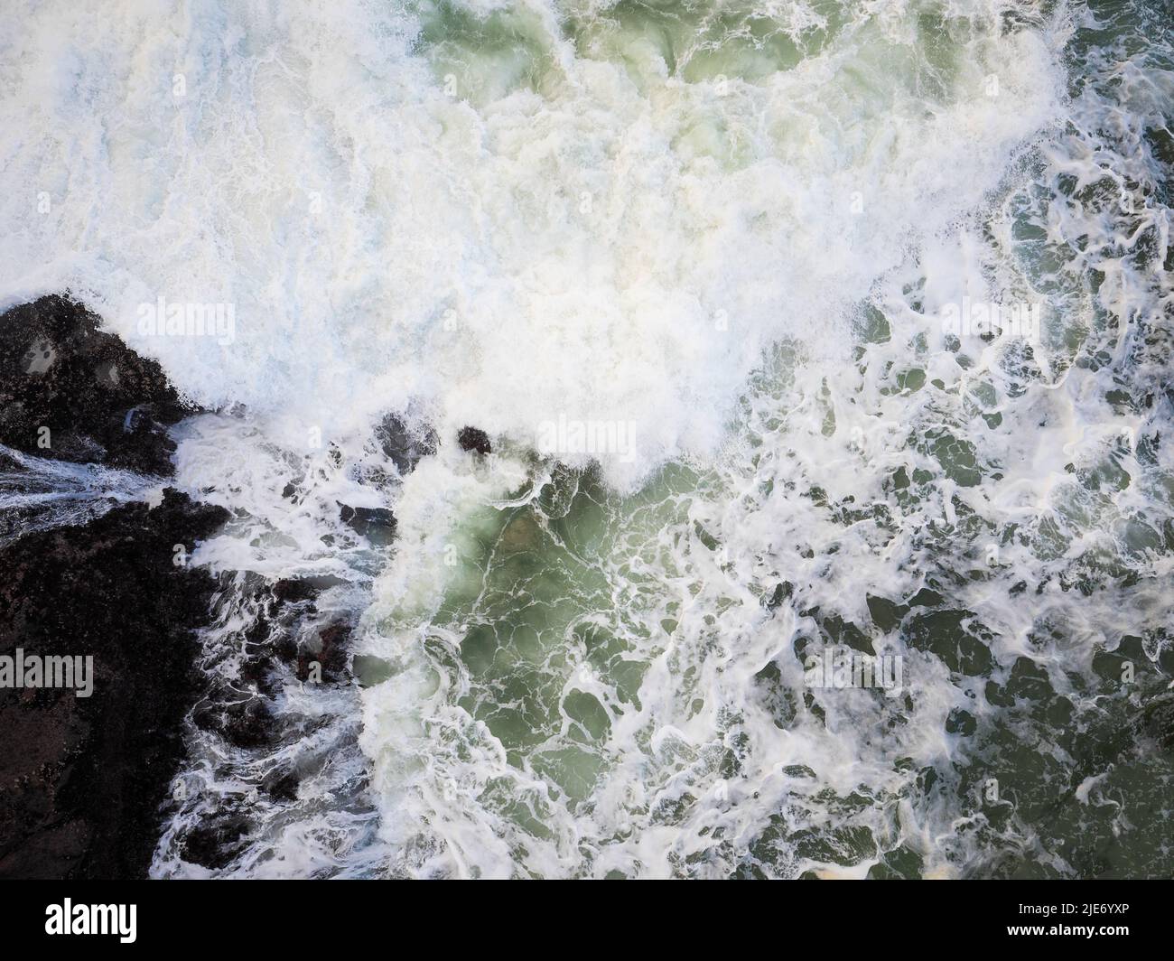 Top view of a storm in the ocean, raging foamy white waves crashing on ...