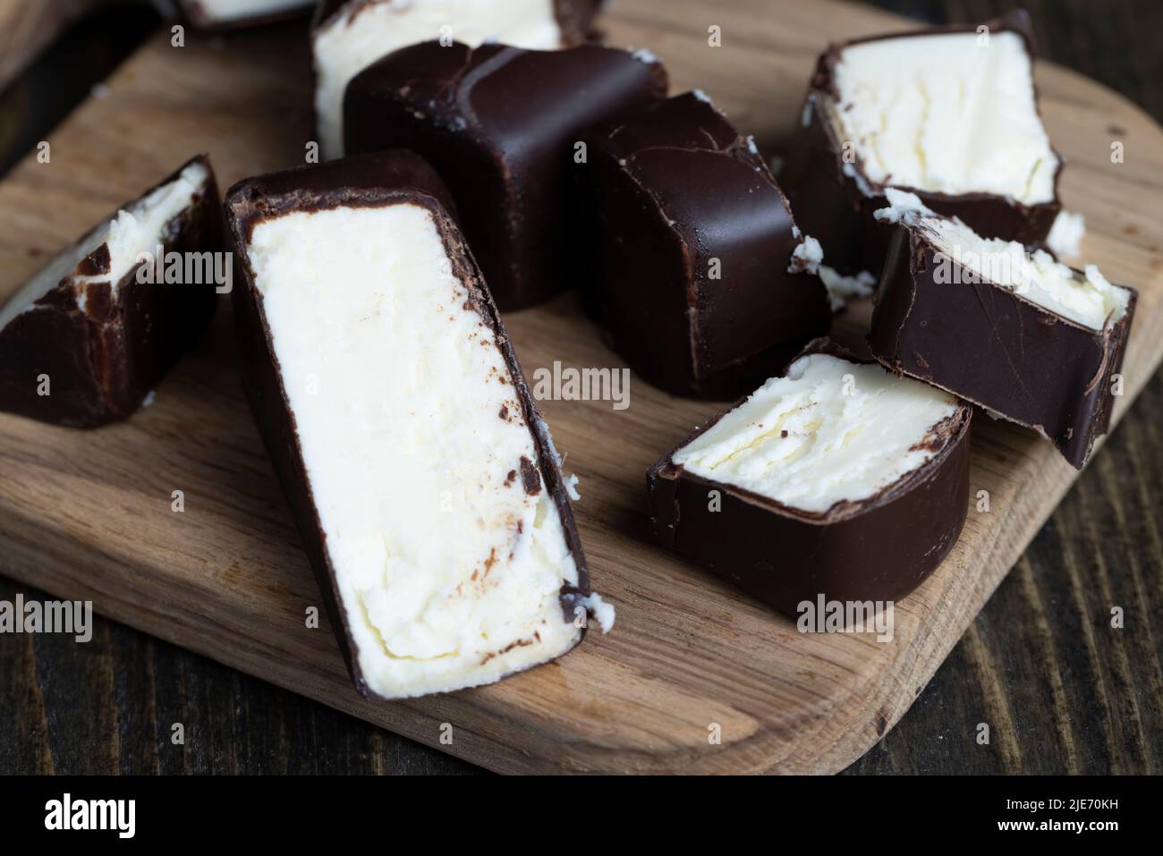 curd cheese in milk chocolate on the table, cut into pieces dessert of ...