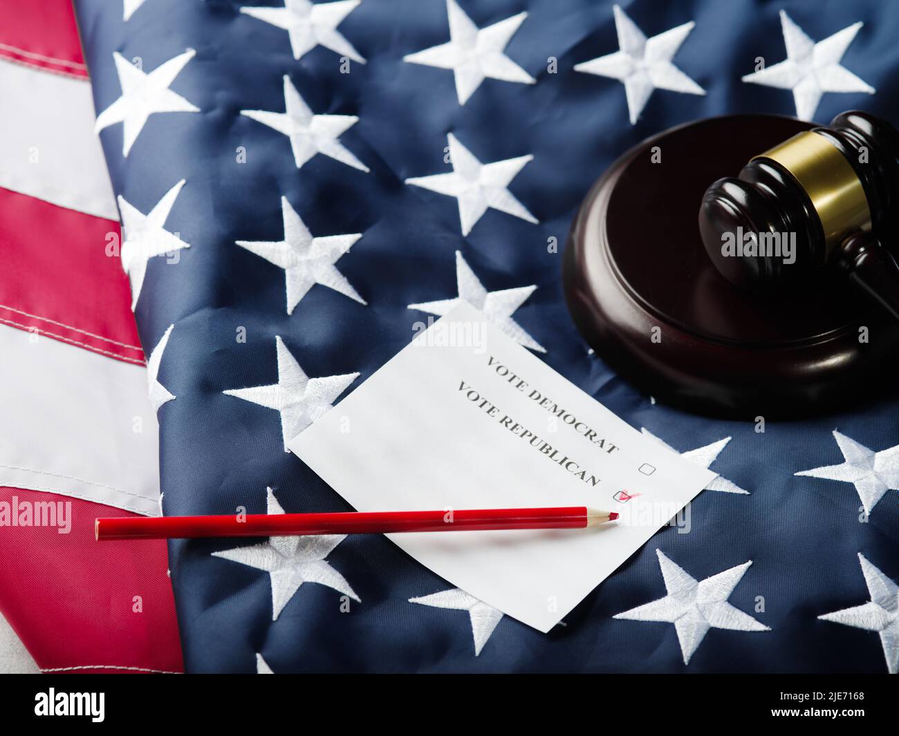 Against the background of the American flag is a ballot paper, a judge ...