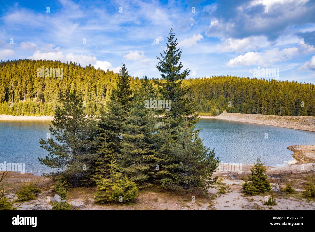A small blue reflecting lake and clear mountain cool water with stone ...