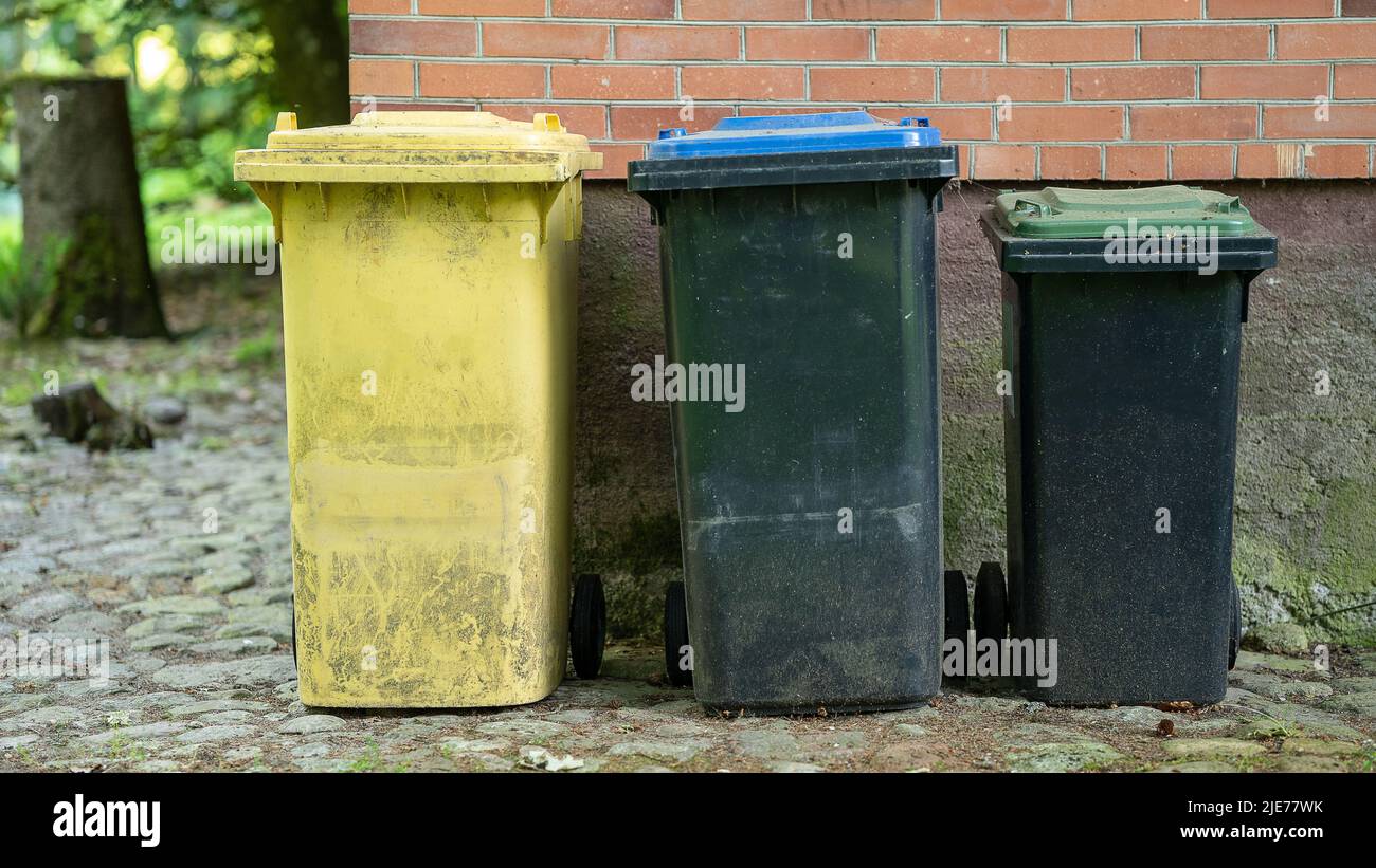 Three recycle bins standing at house wall Stock Photo - Alamy