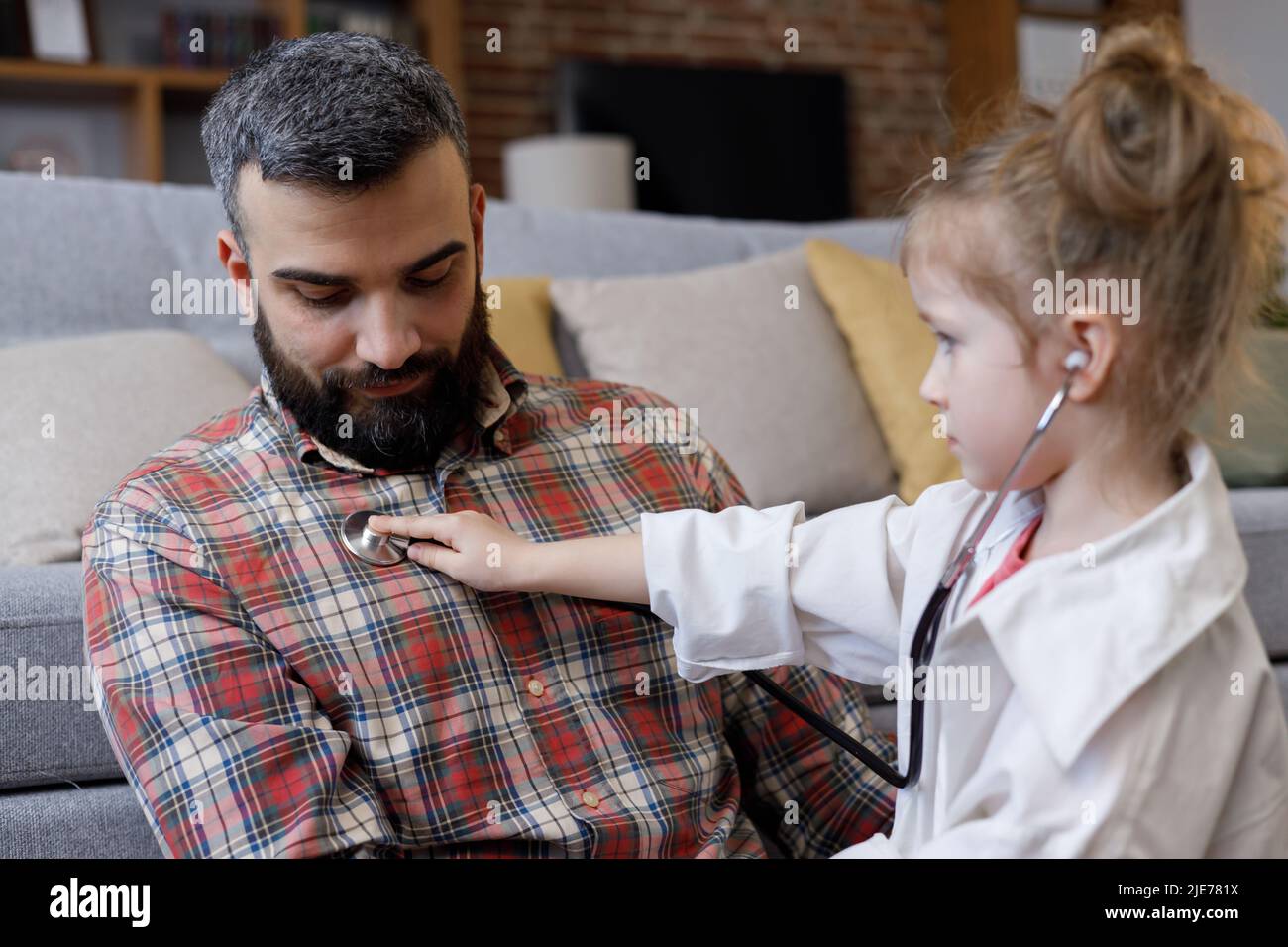 Cute small girl playing doctor with her father. Funny child holds ...