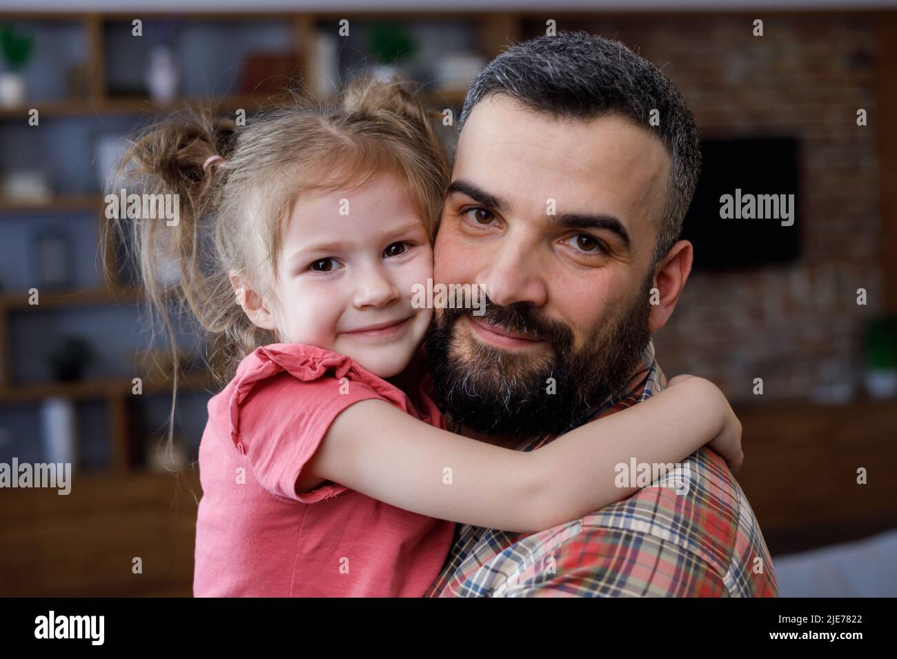 Happy family portrait. Cute girl hugging her beloved dad around neck ...