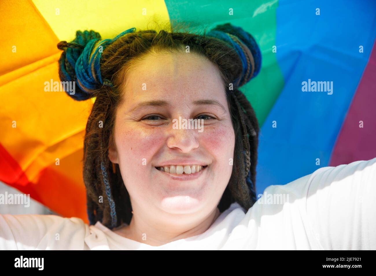 Warsaw, Poland. 25th June, 2022. A woman with the rainbow flag smiles ...