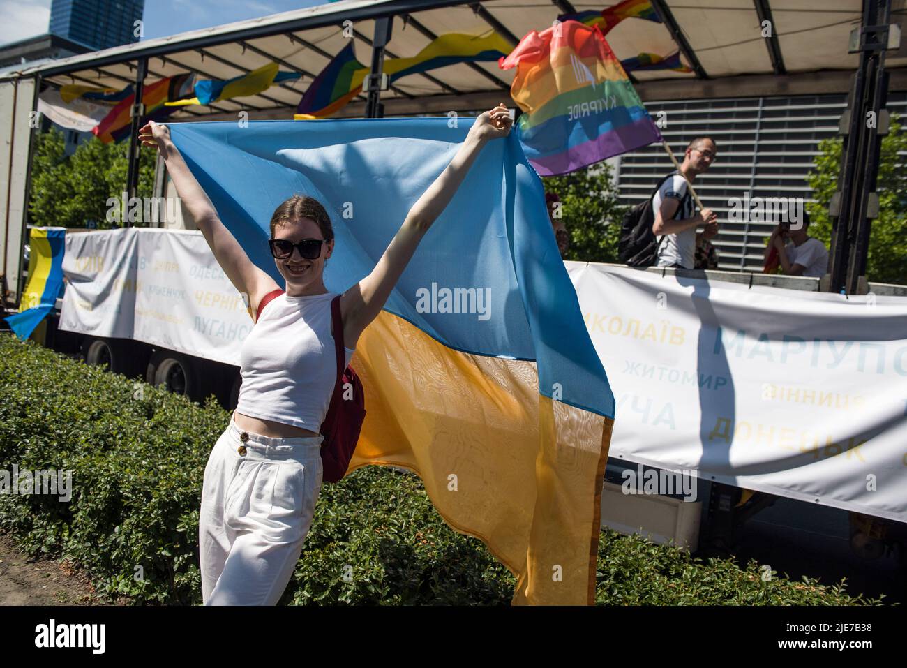 A participant holds a rainbow and Ukrainian flag during the Warsaw ...