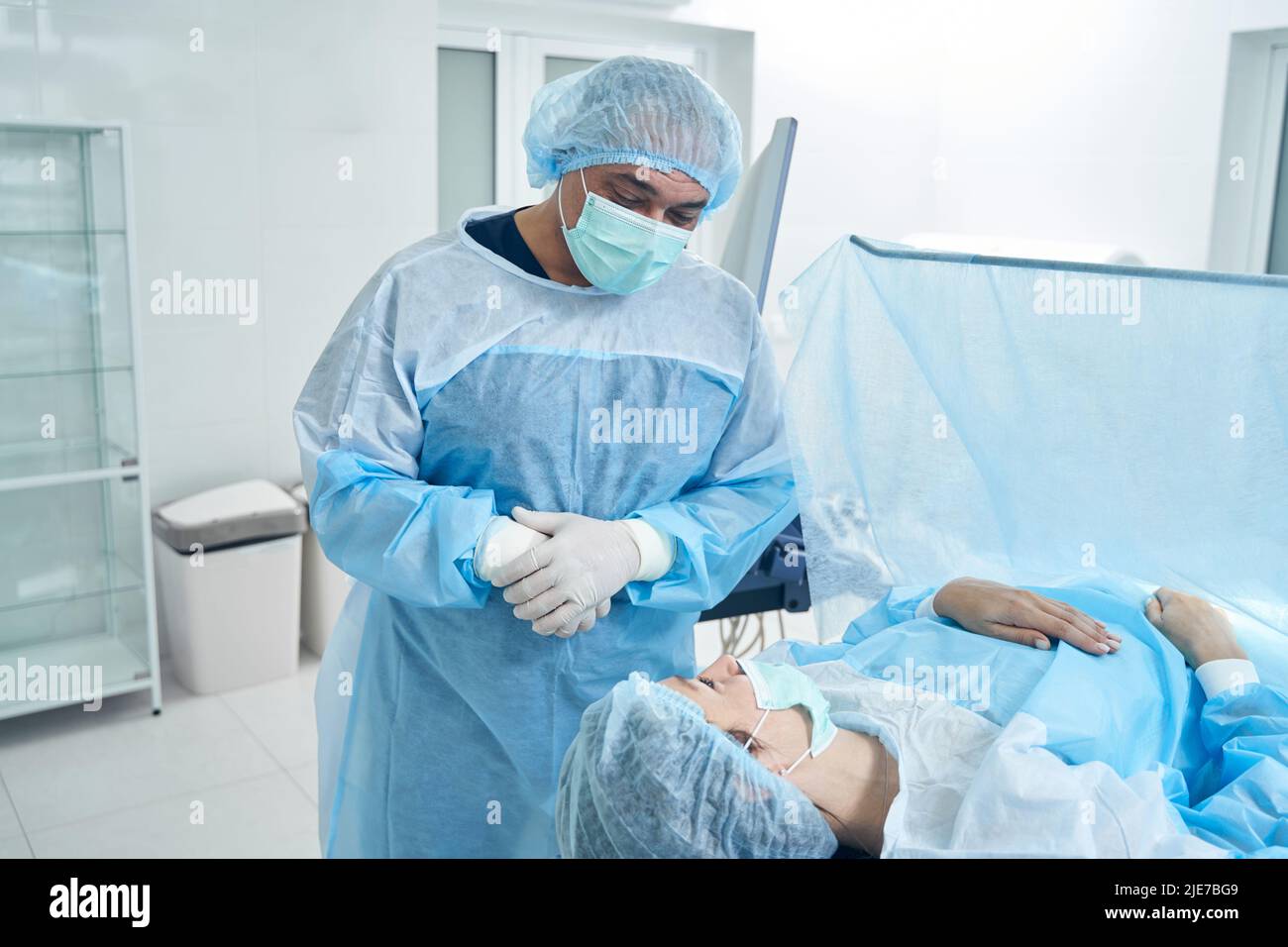 Calm surgeon talking to the patient in operation theatre Stock Photo ...
