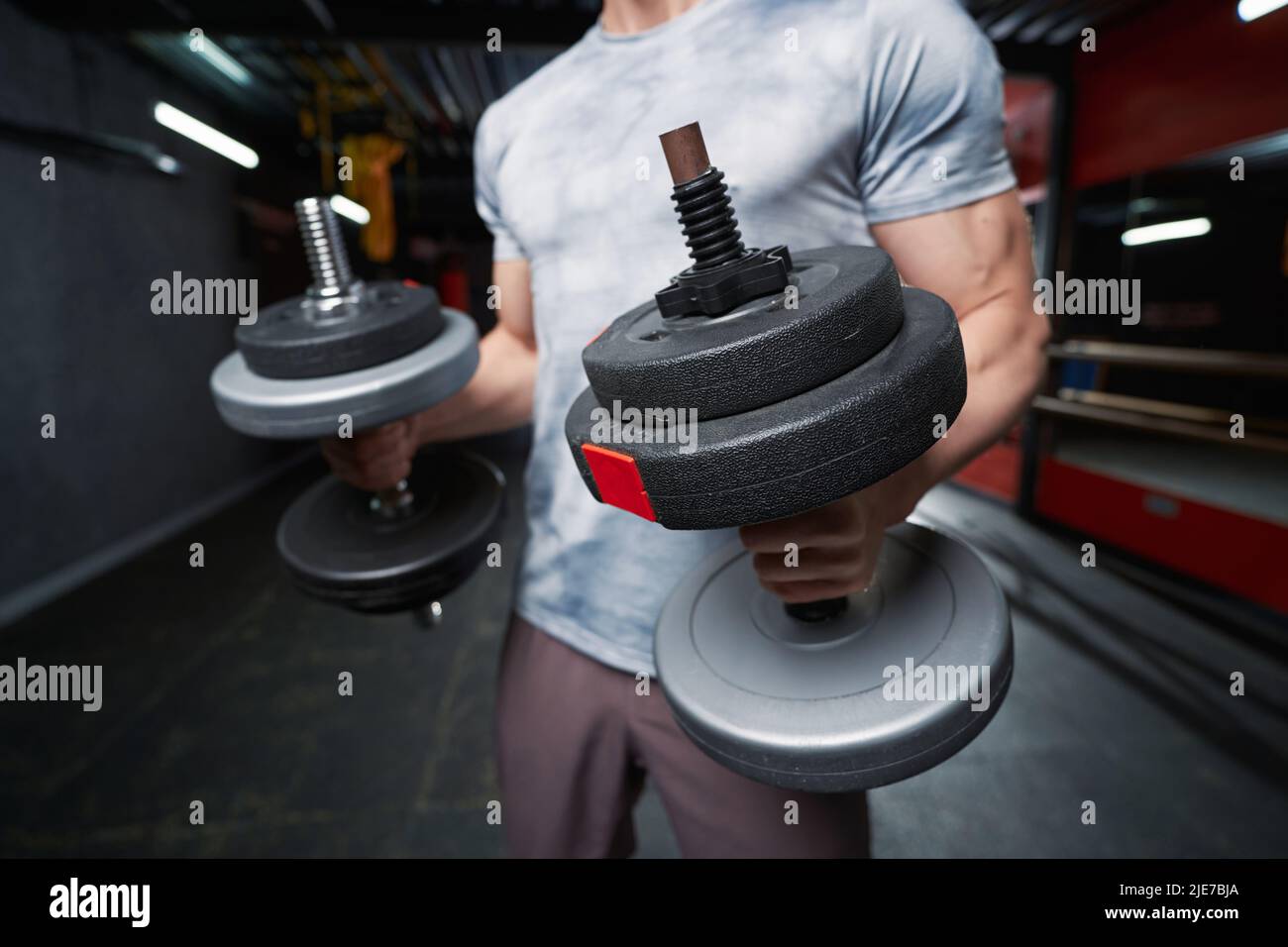 Athletic person working out with hand weights at gym Stock Photo - Alamy