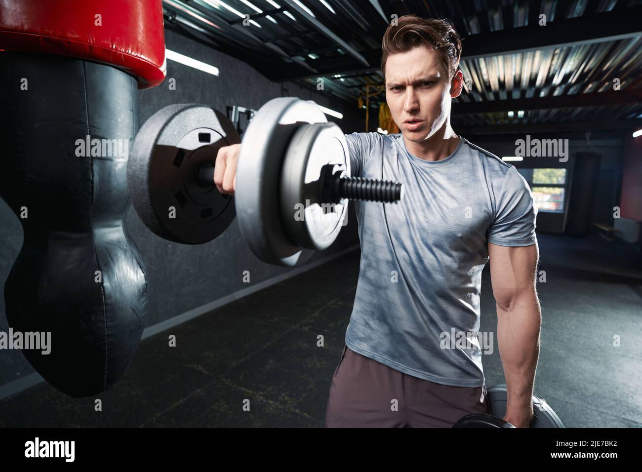 Strong sporty guy working out with hand weights Stock Photo - Alamy