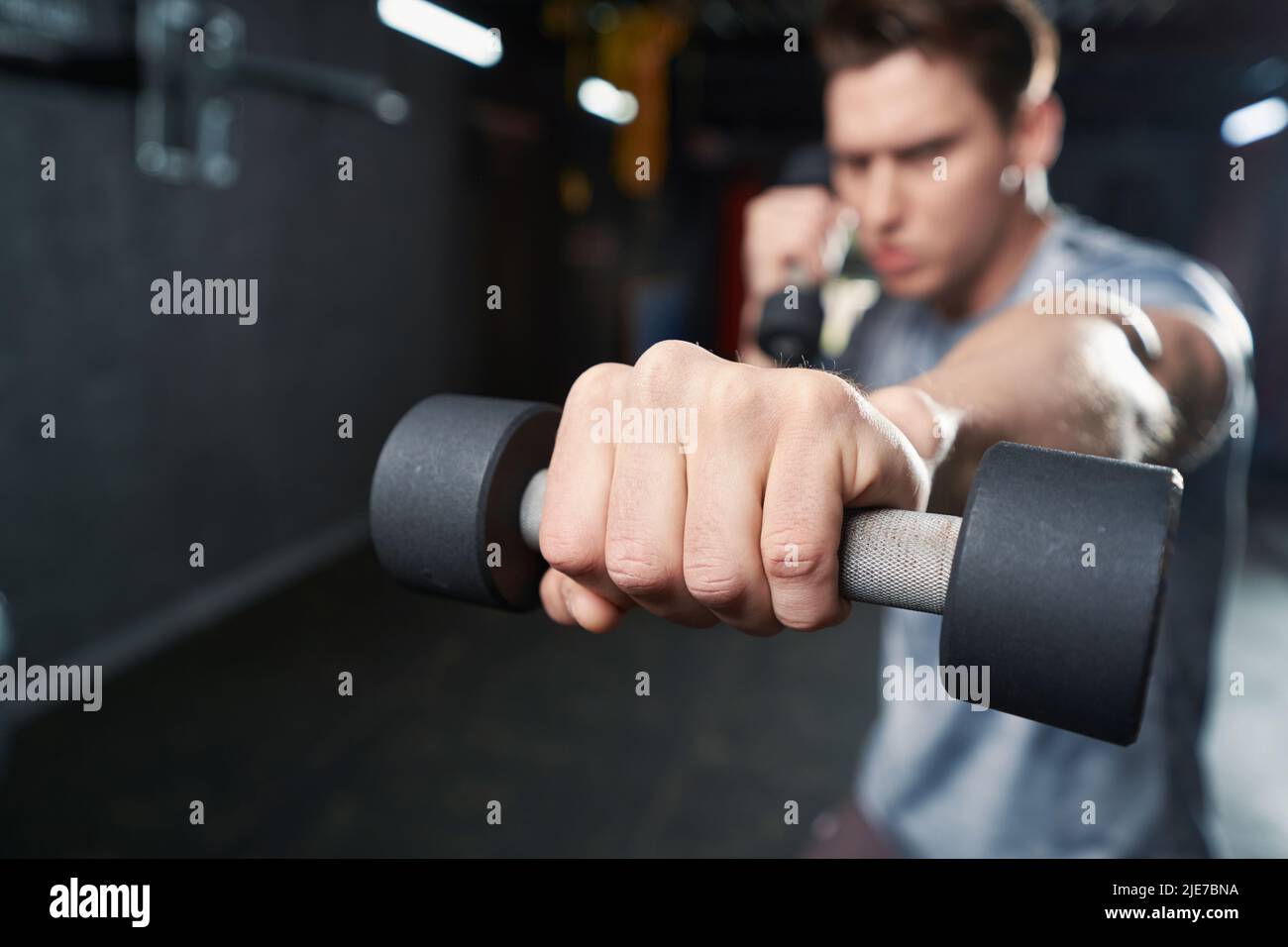 Professional sportsman shadow-boxing with pair of dumbbells Stock Photo ...