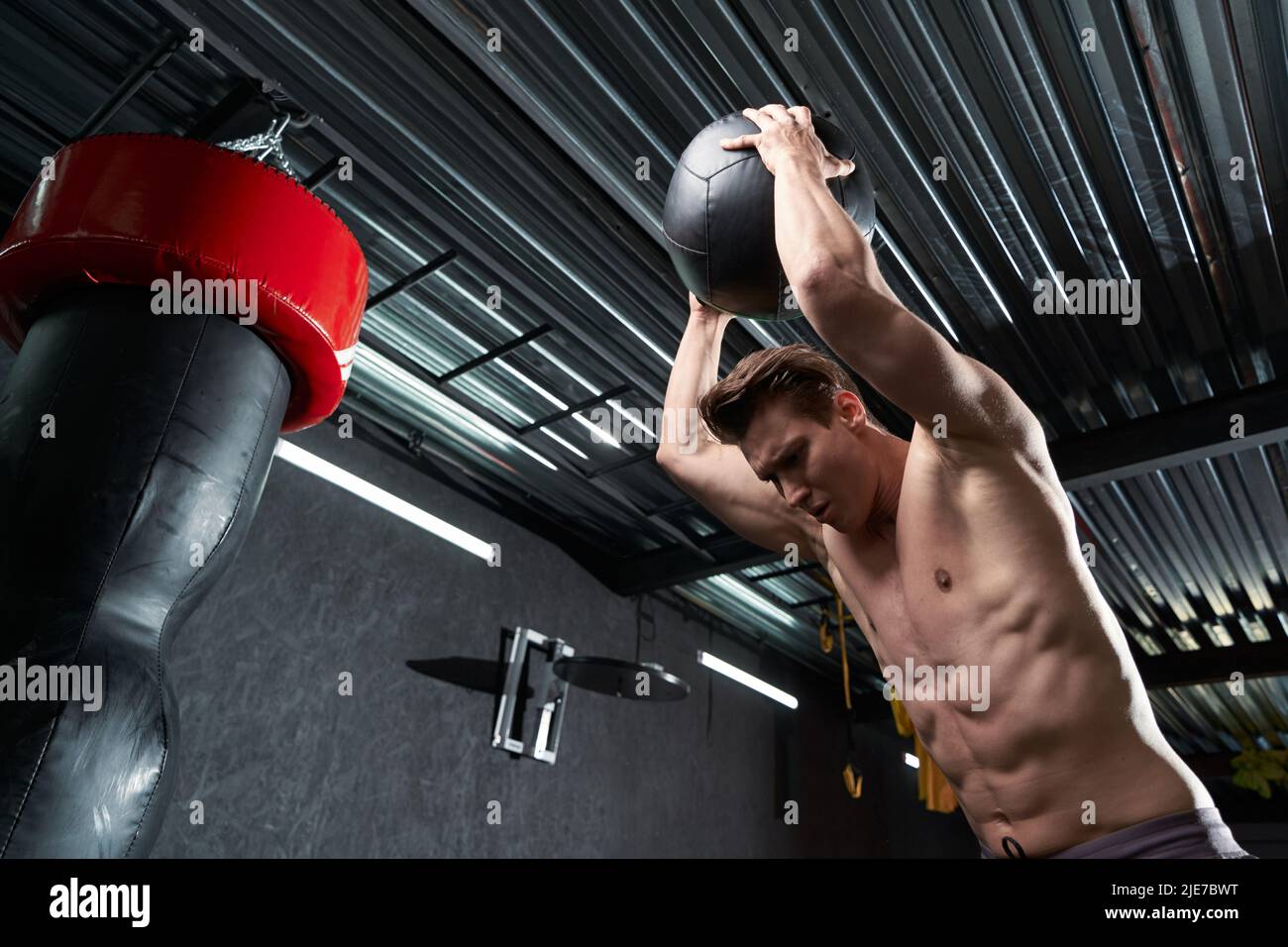 Strong well-built young man exercising at gym Stock Photo - Alamy