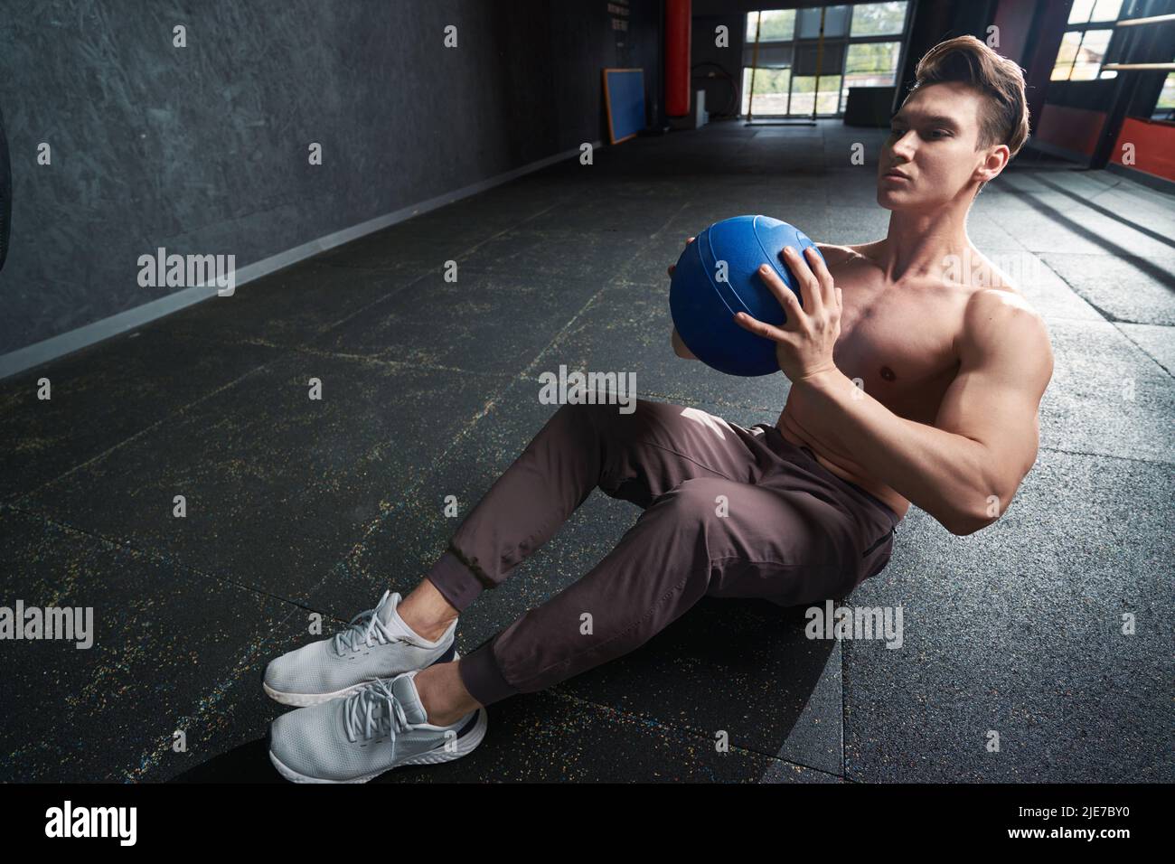 Concentrated sportsman doing ab workout on gym floor Stock Photo - Alamy
