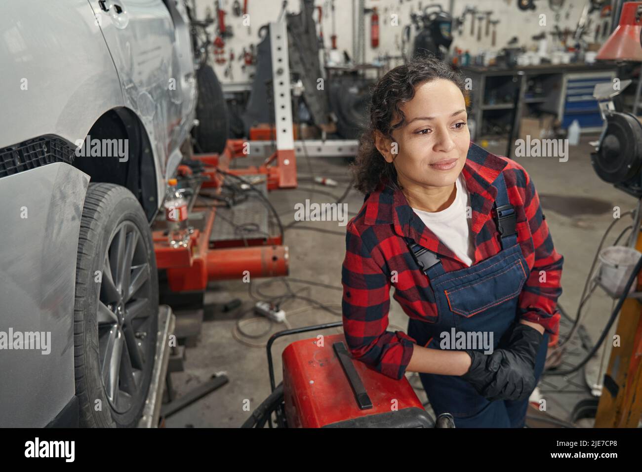 Cheerful female mechanic working at service station Stock Photo - Alamy
