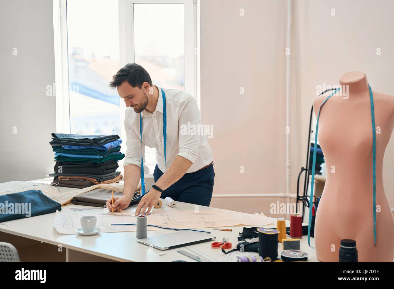 Male dressmaker making new designs in own atelier Stock Photo - Alamy