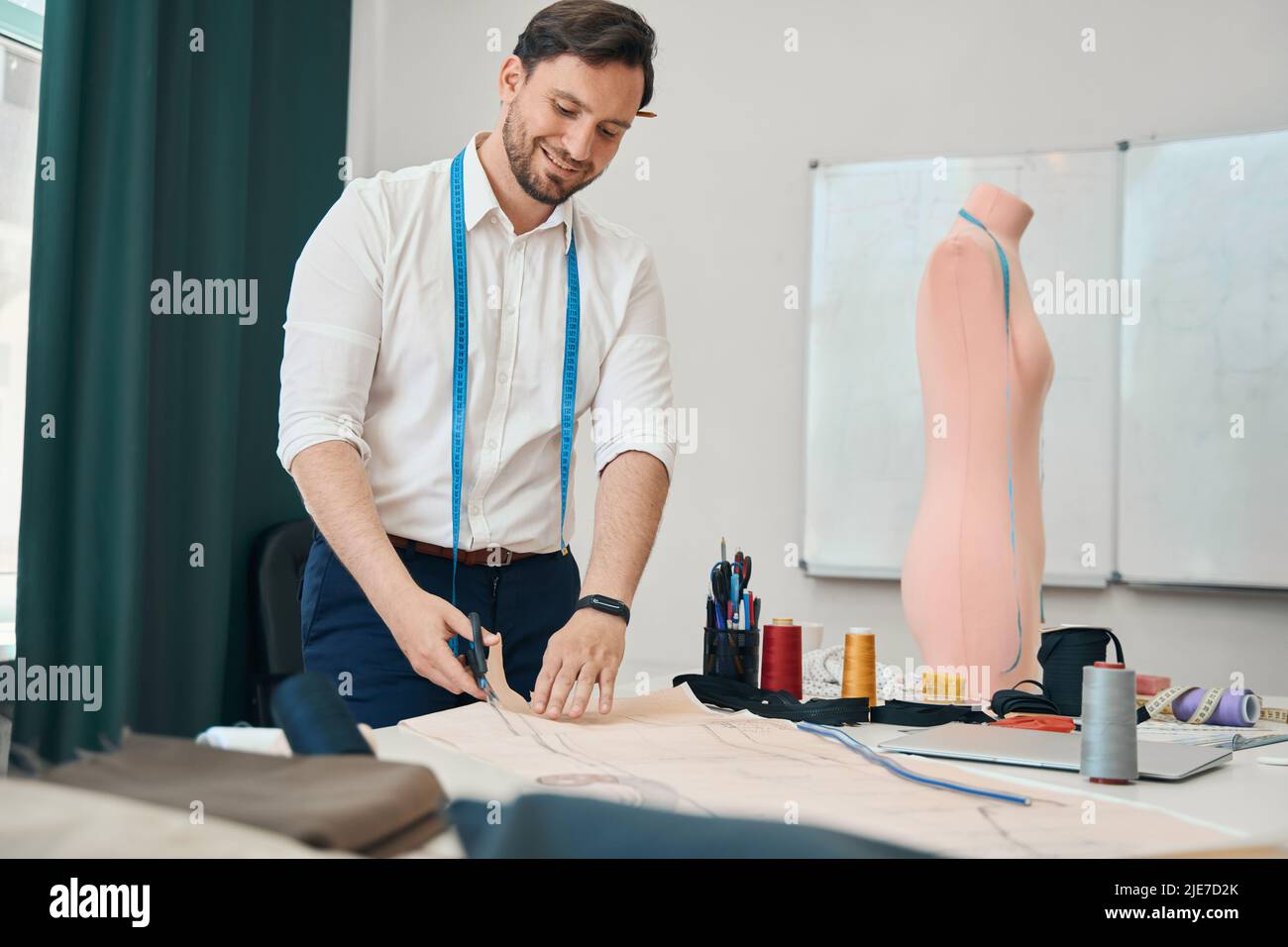 Smiling dressmaker preparing patterns for new clothes Stock Photo - Alamy