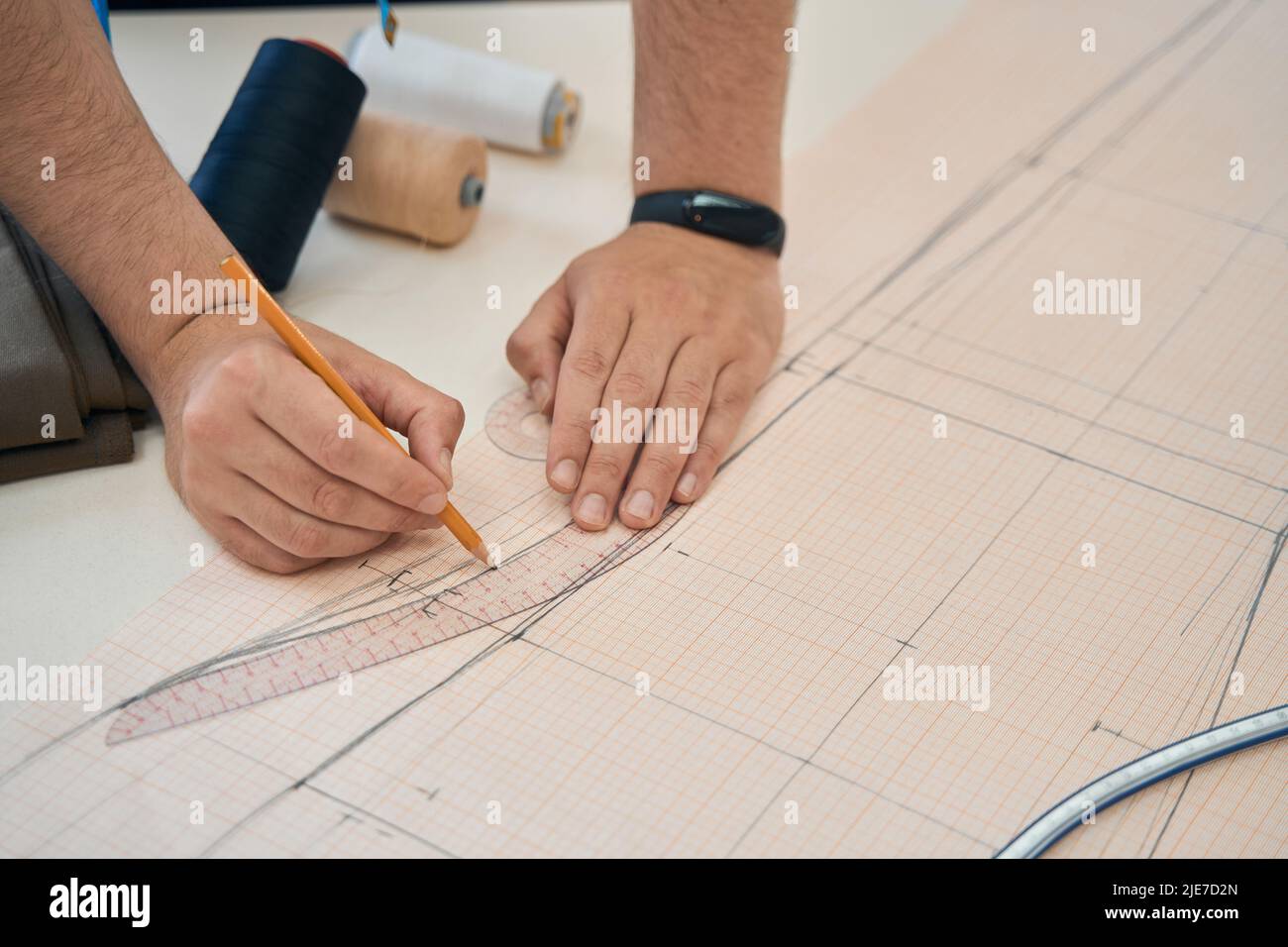 Dressmaker drawing patterns for making new clothes Stock Photo - Alamy