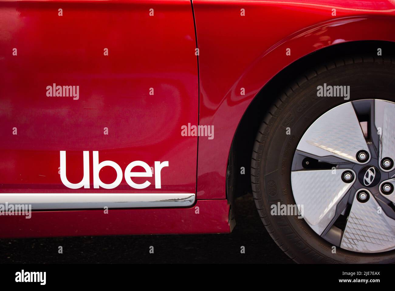 Madrid Spain. May 1 2022 Red cab, branded car with white Uber logo on ...