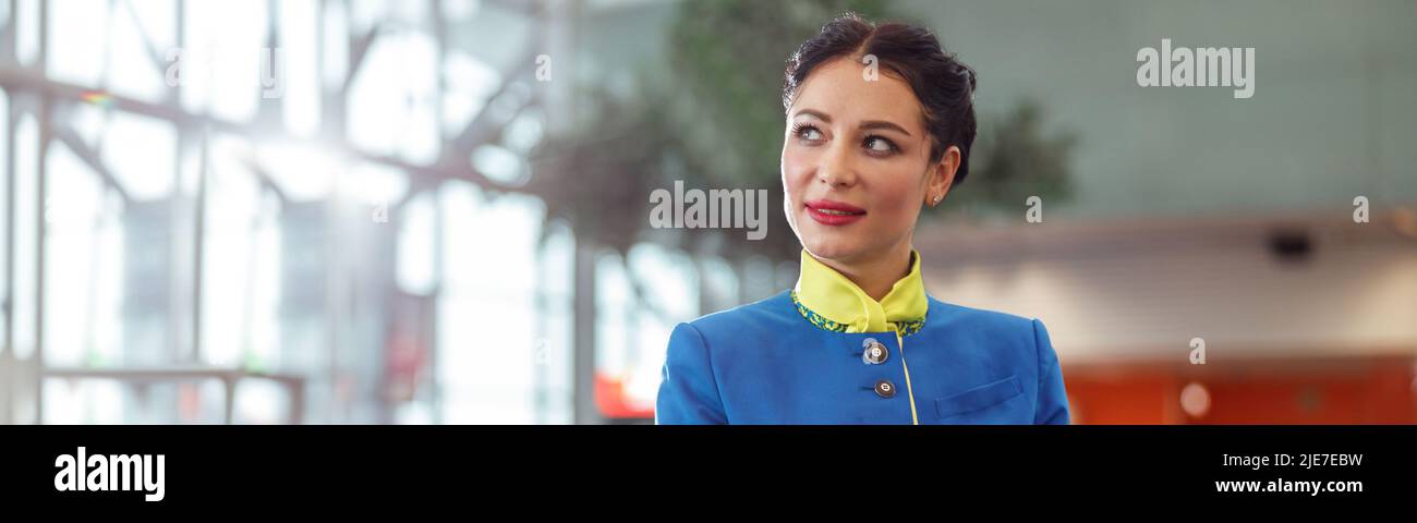 Female flight attendant standing in airport terminal Stock Photo - Alamy