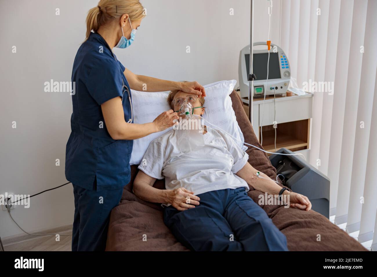 Doctor putting on a breathing mask on a female patient with covid-19 ...