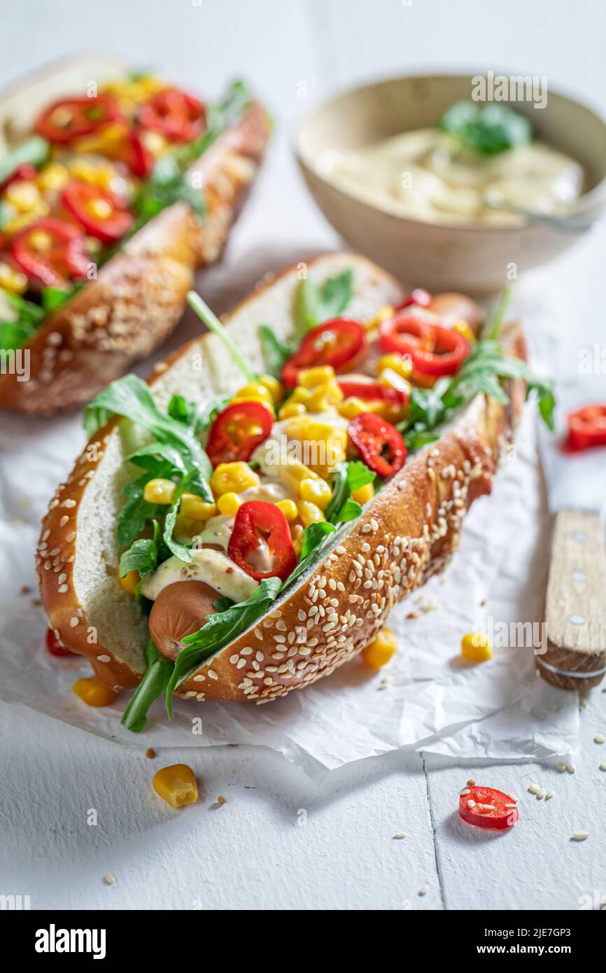 Unhealthy and tasty hot dogs with arugula, chilli pepper and corn ...