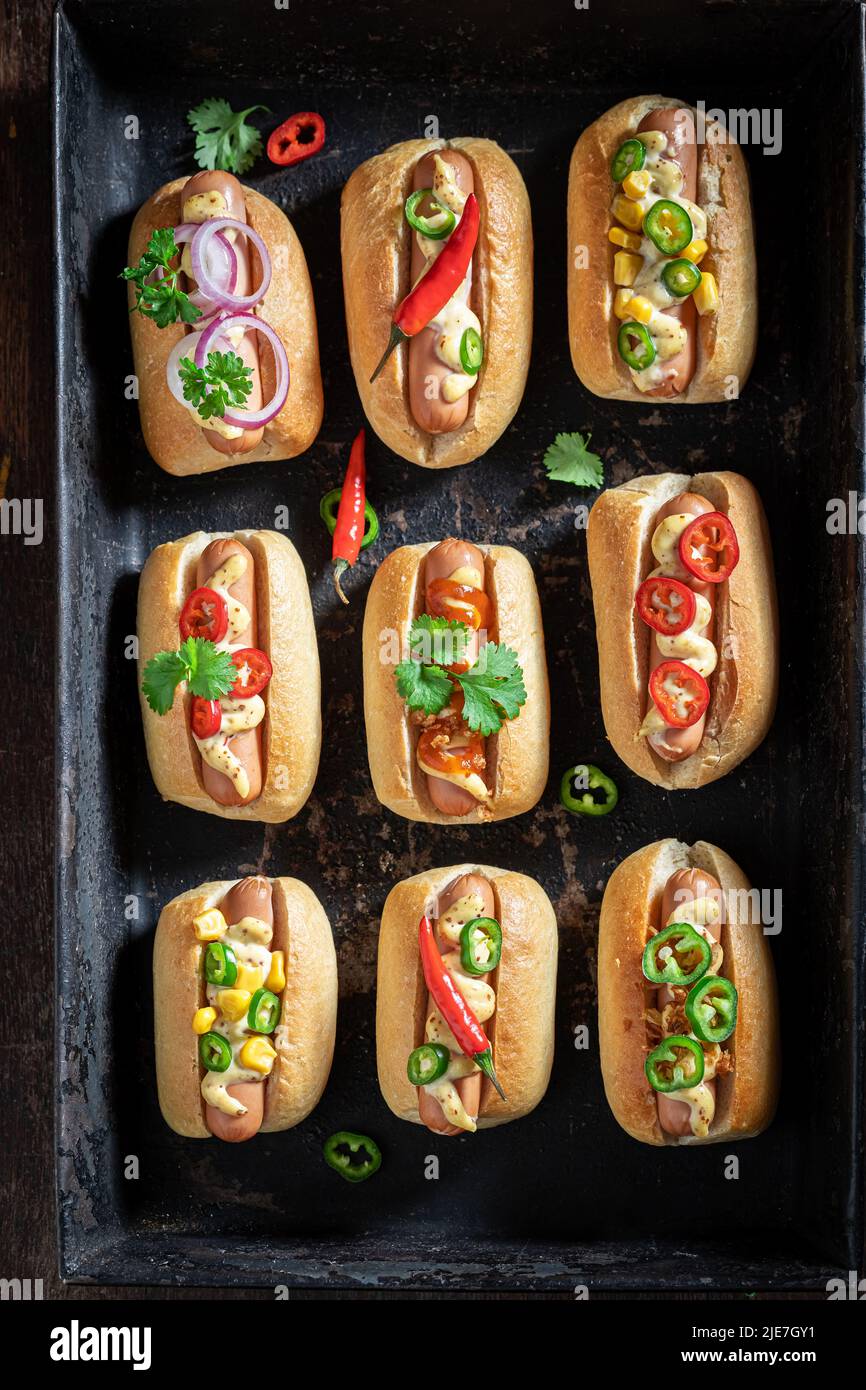 Unhealthy and tasty mini hot dogs with mustard and herbs. Mini hot dogs ...
