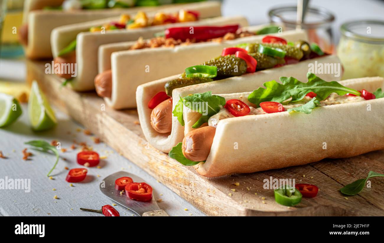 Unhealthy and tasty hot dogs with vegetables, sauce and herbs. Hot dogs ...