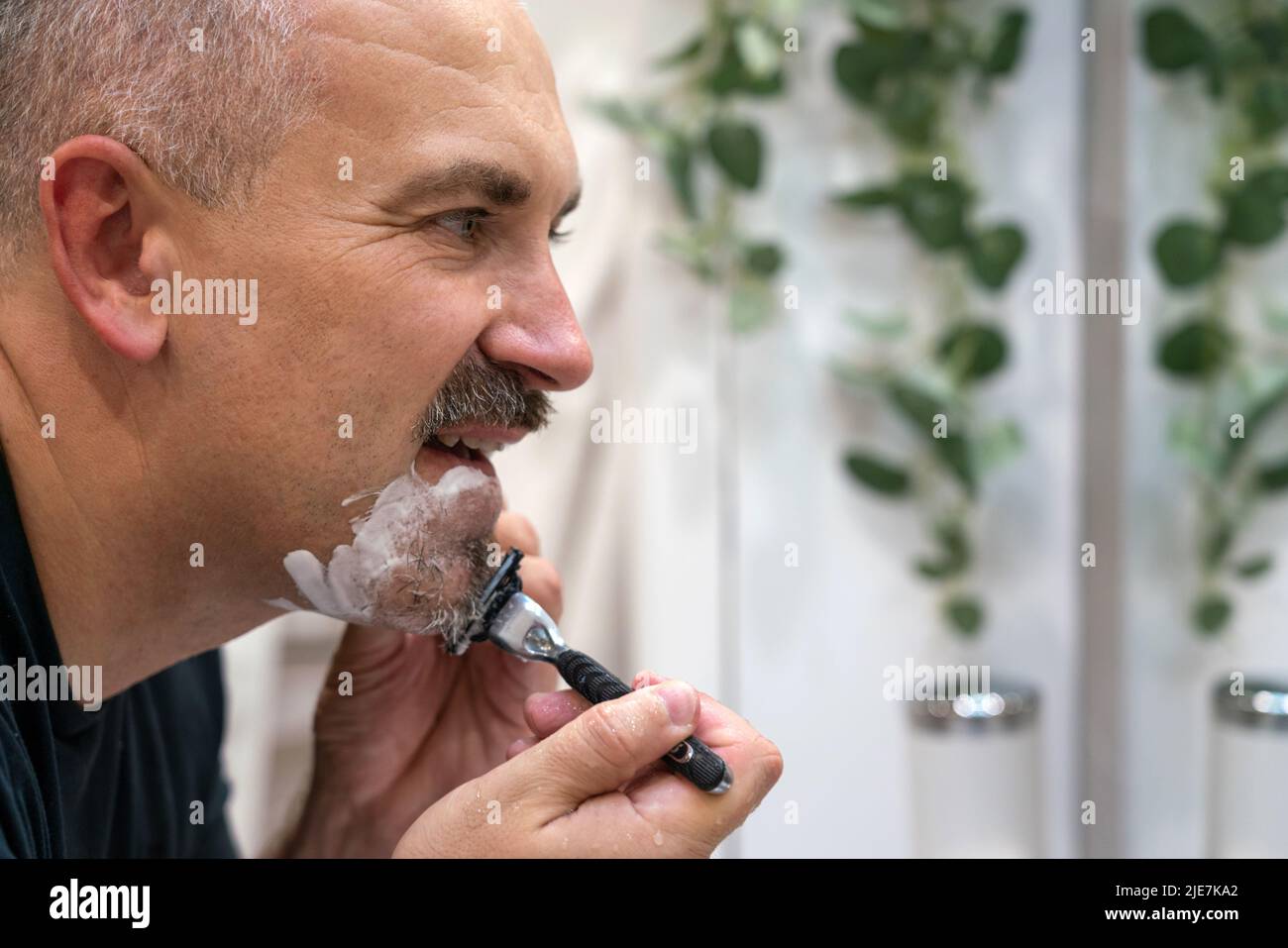 Man shaving with razor using foam in bathroom in the morning Stock ...