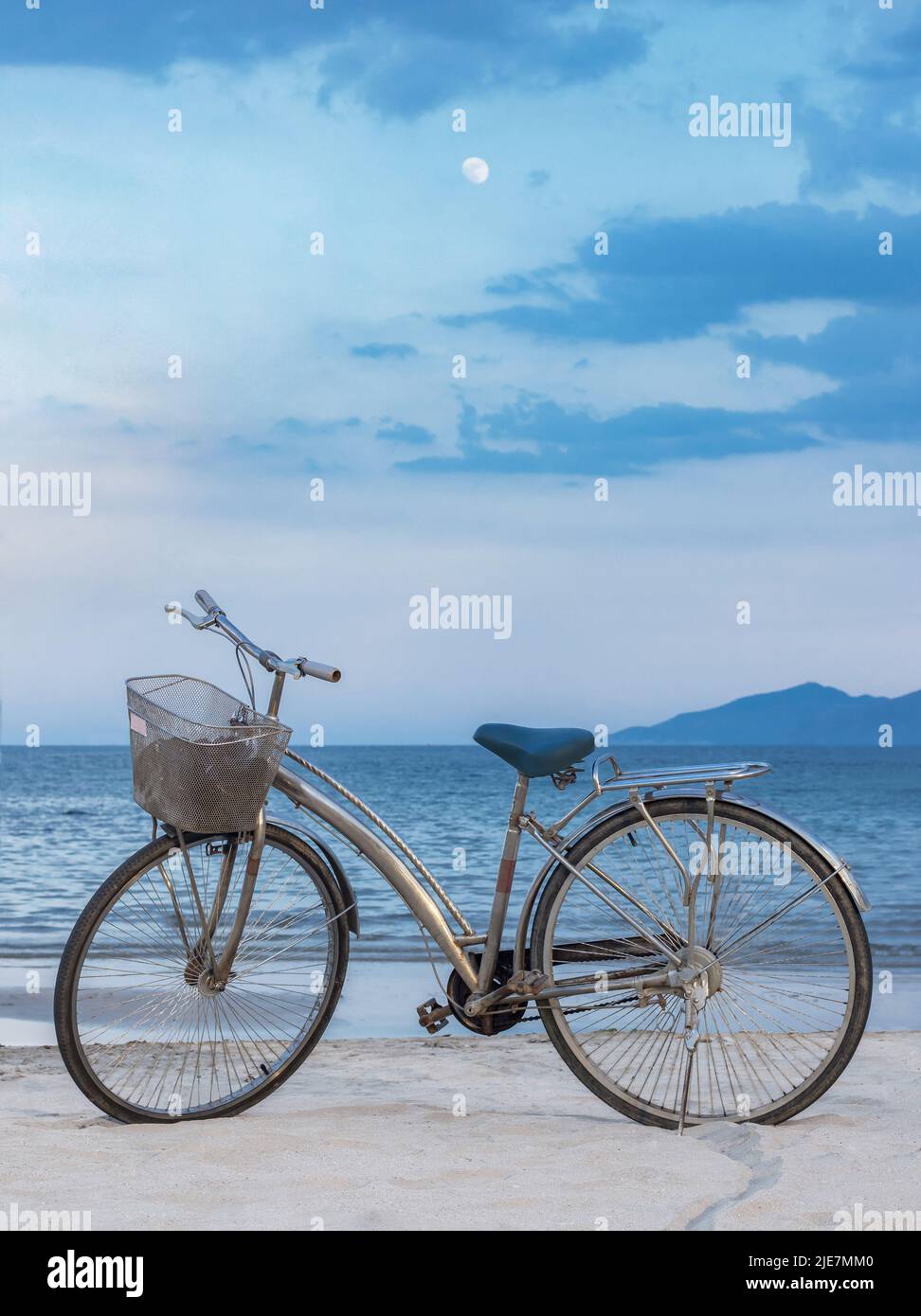 The bike is on the sandy beach. Against the background of the blue sky ...