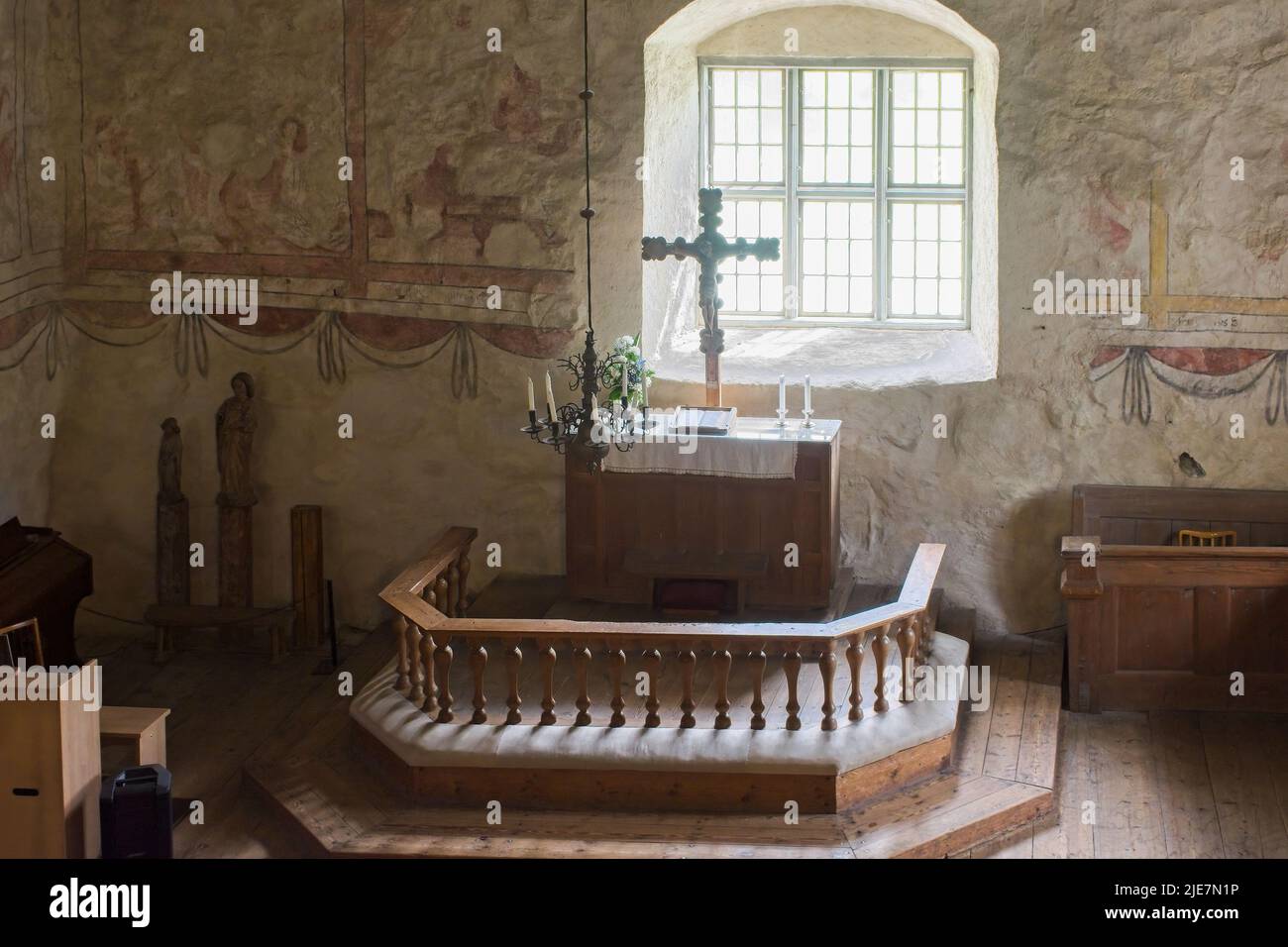 Altar with a cross before an window in an medieval stone church of ...