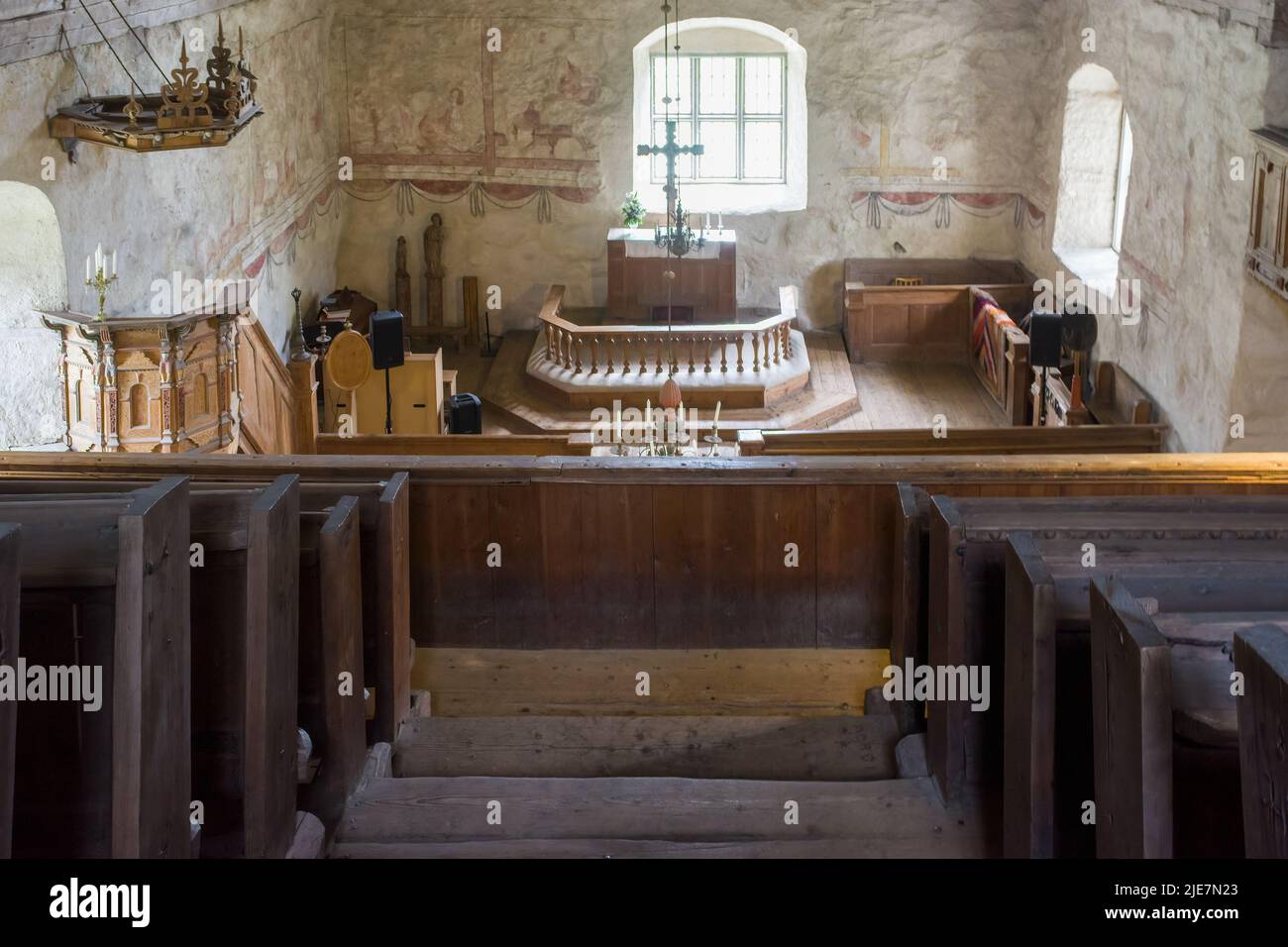 Altar with a cross before an window in an medieval stone church of ...