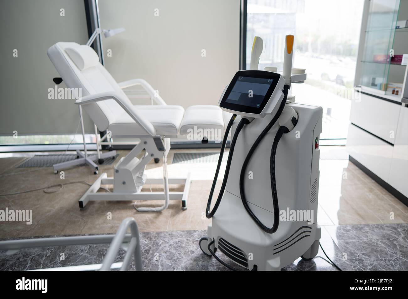 Empty beautician office with white couch and photorejuvenation machine ...