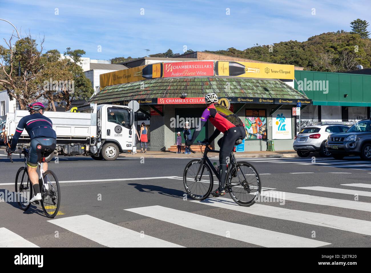 Two men cycling o road bikes at an intersection pelican crossing in ...