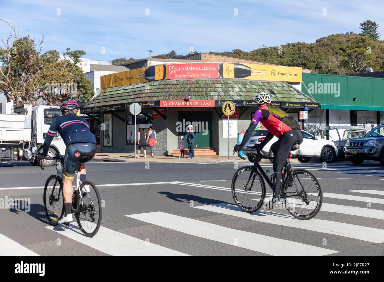 Two men cycling o road bikes at an intersection pelican crossing in ...