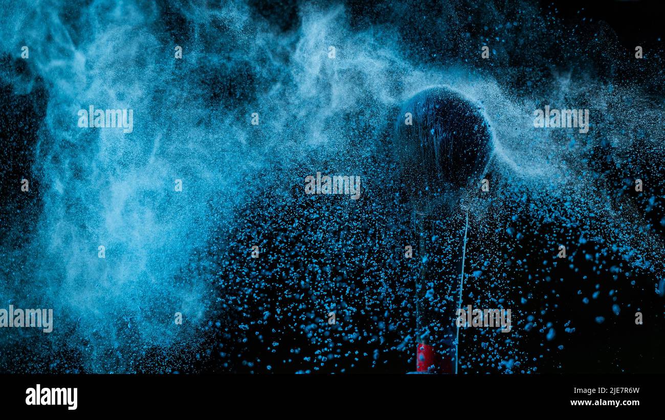 Brush shakes off colored powder on a black background Stock Photo - Alamy