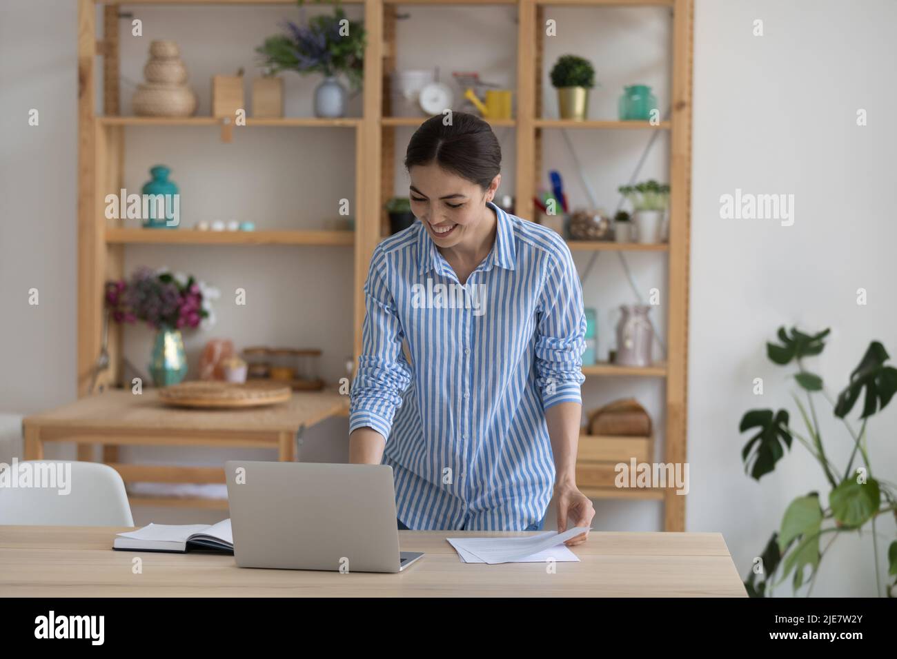 Businesslady standing at workplace finish paperwork looks satisfied by ...