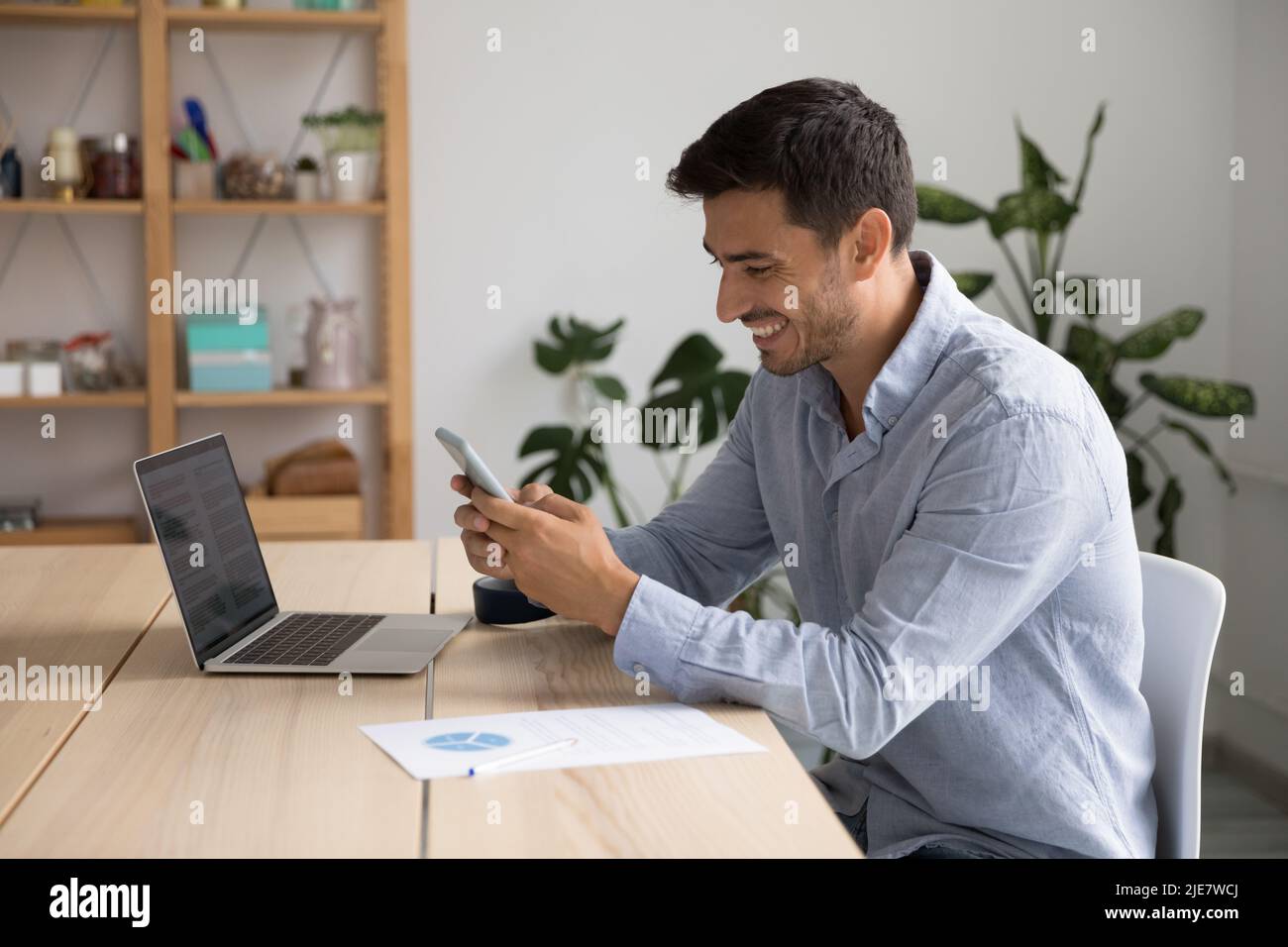 Millennial Hispanic office employee use cellphone at workplace Stock ...