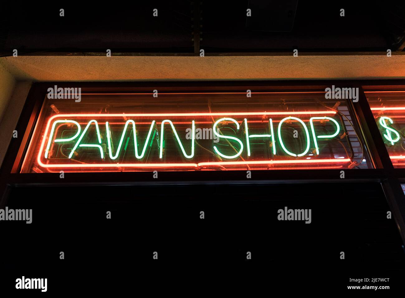 Pawn shop sign glowing from a dark window Stock Photo - Alamy