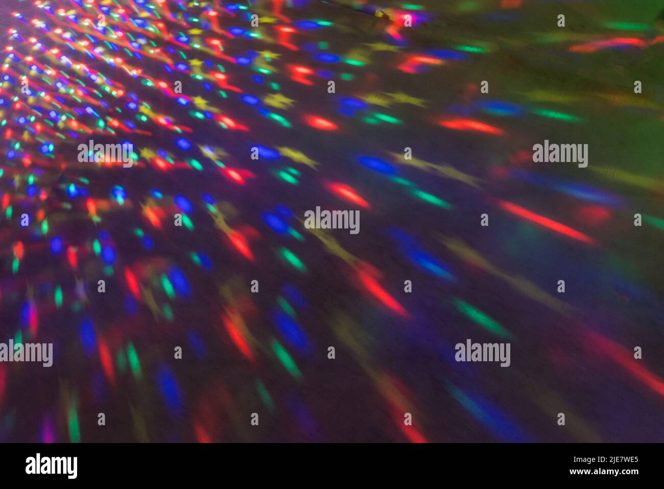 Red green blue yellow abstract patterns of light spilling across a dark ...