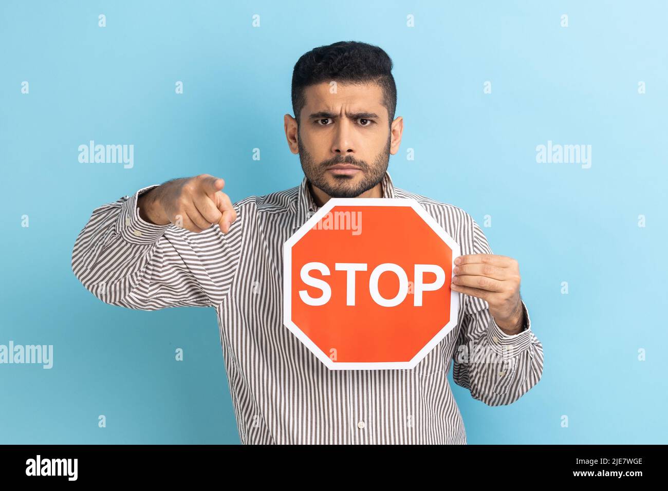 Portrait of serious business holding big red stop road sign and ...
