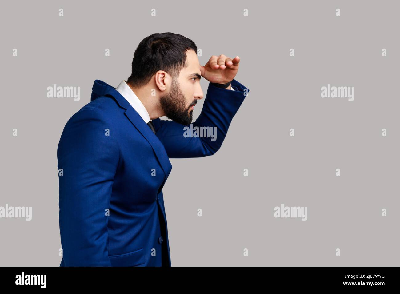 Side view of serious concentrated bearded man watching far away with ...