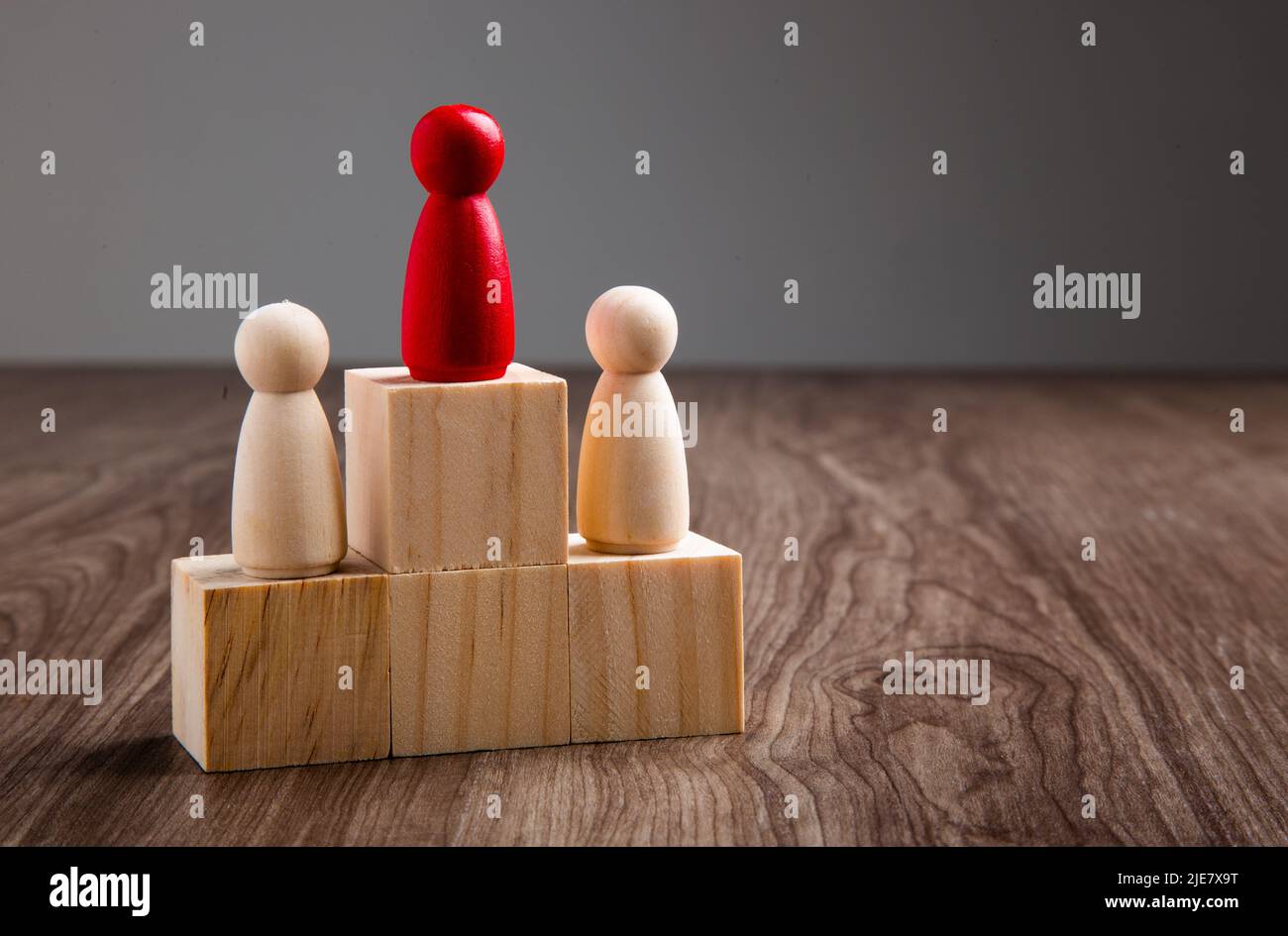 woodenl figures standing on wooden podium with business team ...