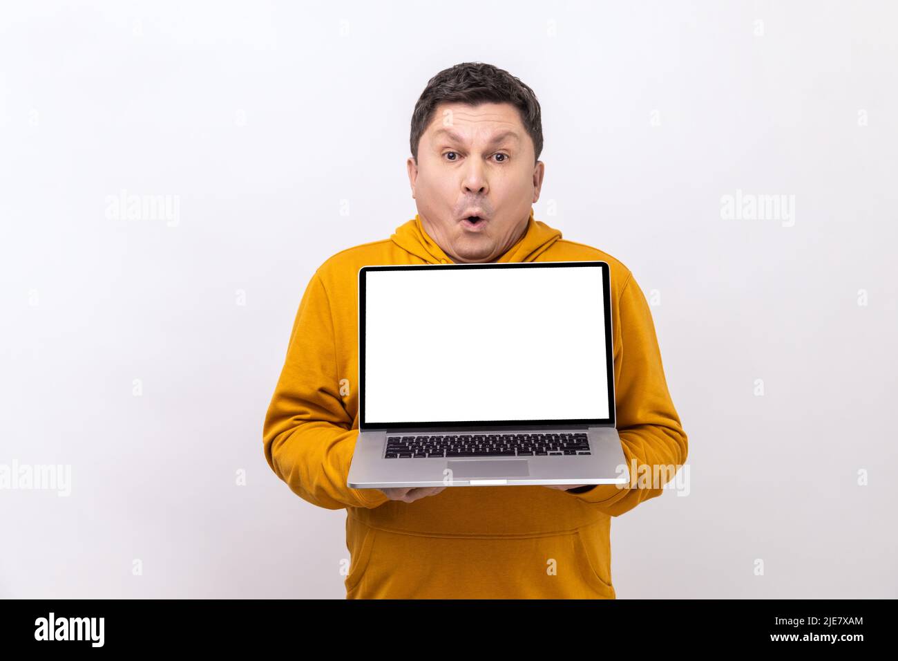 Surprised astonished man holding laptop and looking at camera with open ...